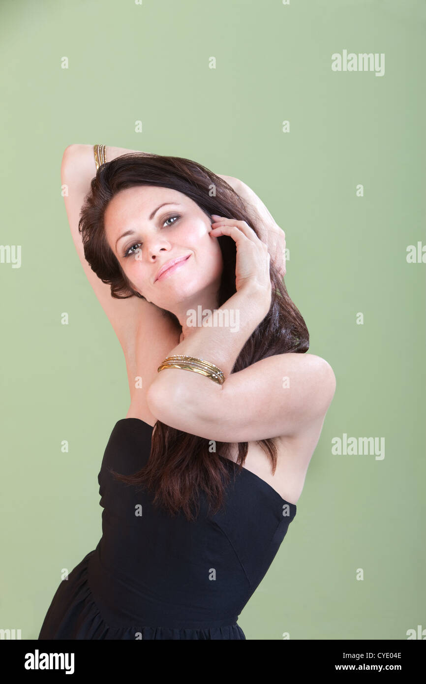 Smiling young woman with arms around her head Stock Photo - Alamy