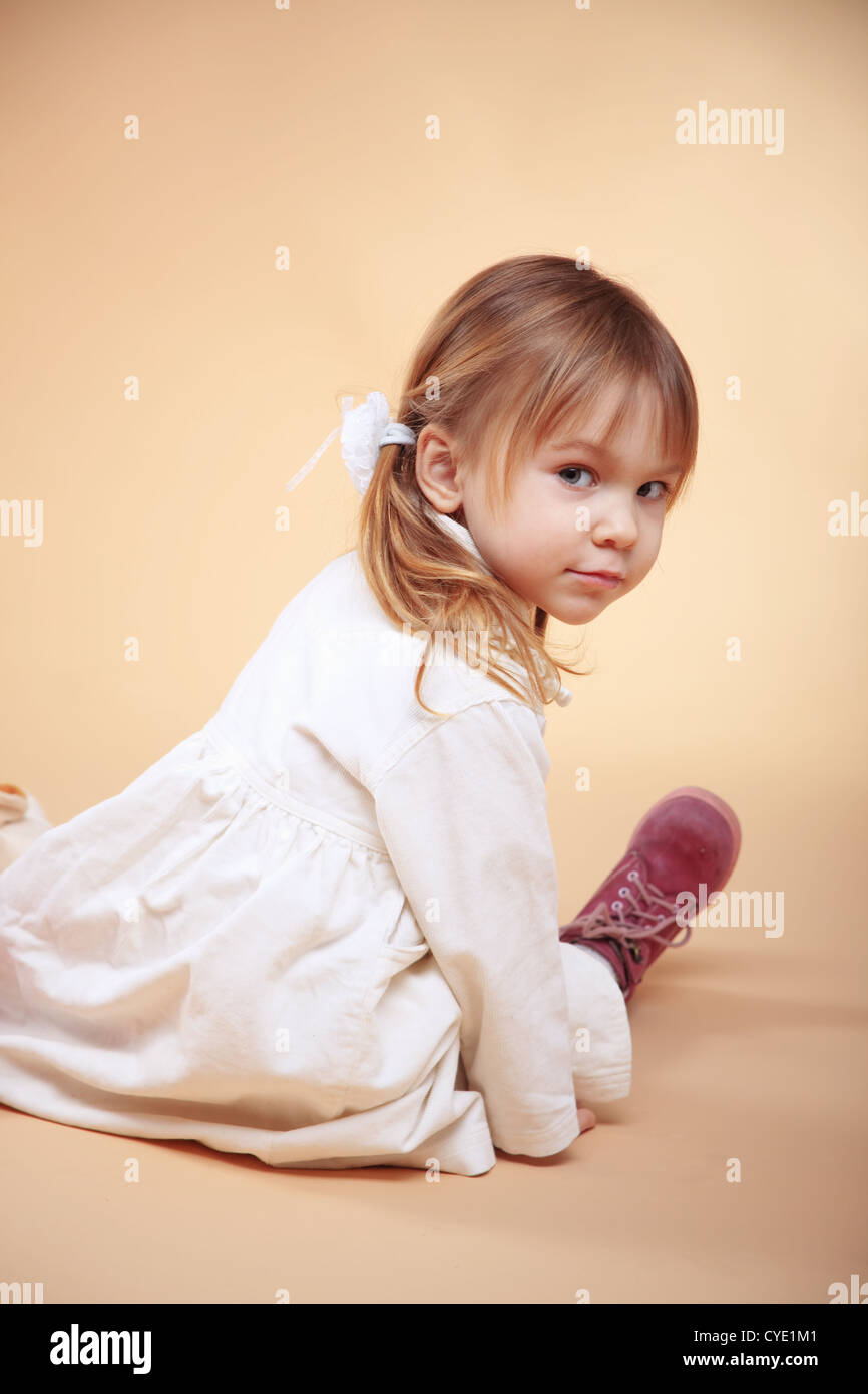 Cute kid girl posing over beige Stock Photo - Alamy