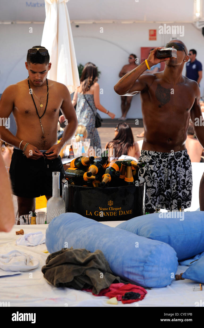 British party revelers next to large bucket full of dozens of empty ...