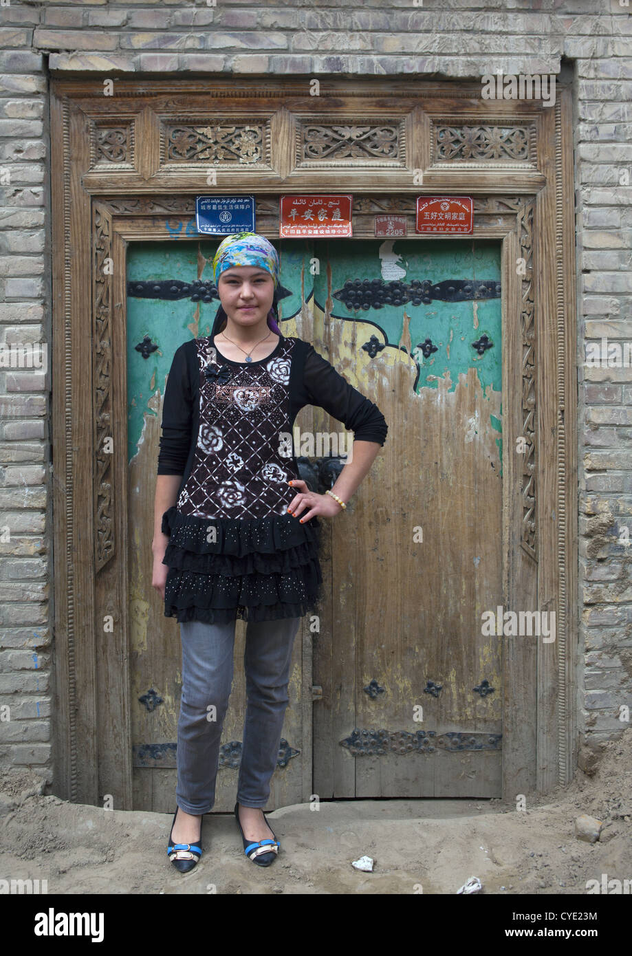 Young Uyghur Woman Posing In Front Of A Traditional Door In Old Town ...