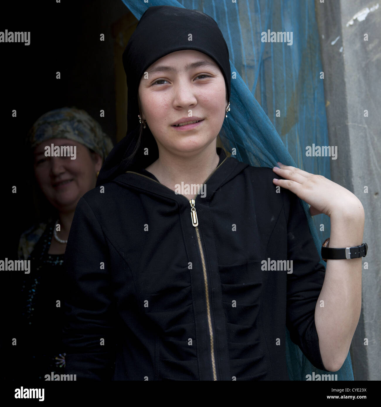 Young Uyghur Woman And Her Mother At The Entrance Of Their House ...