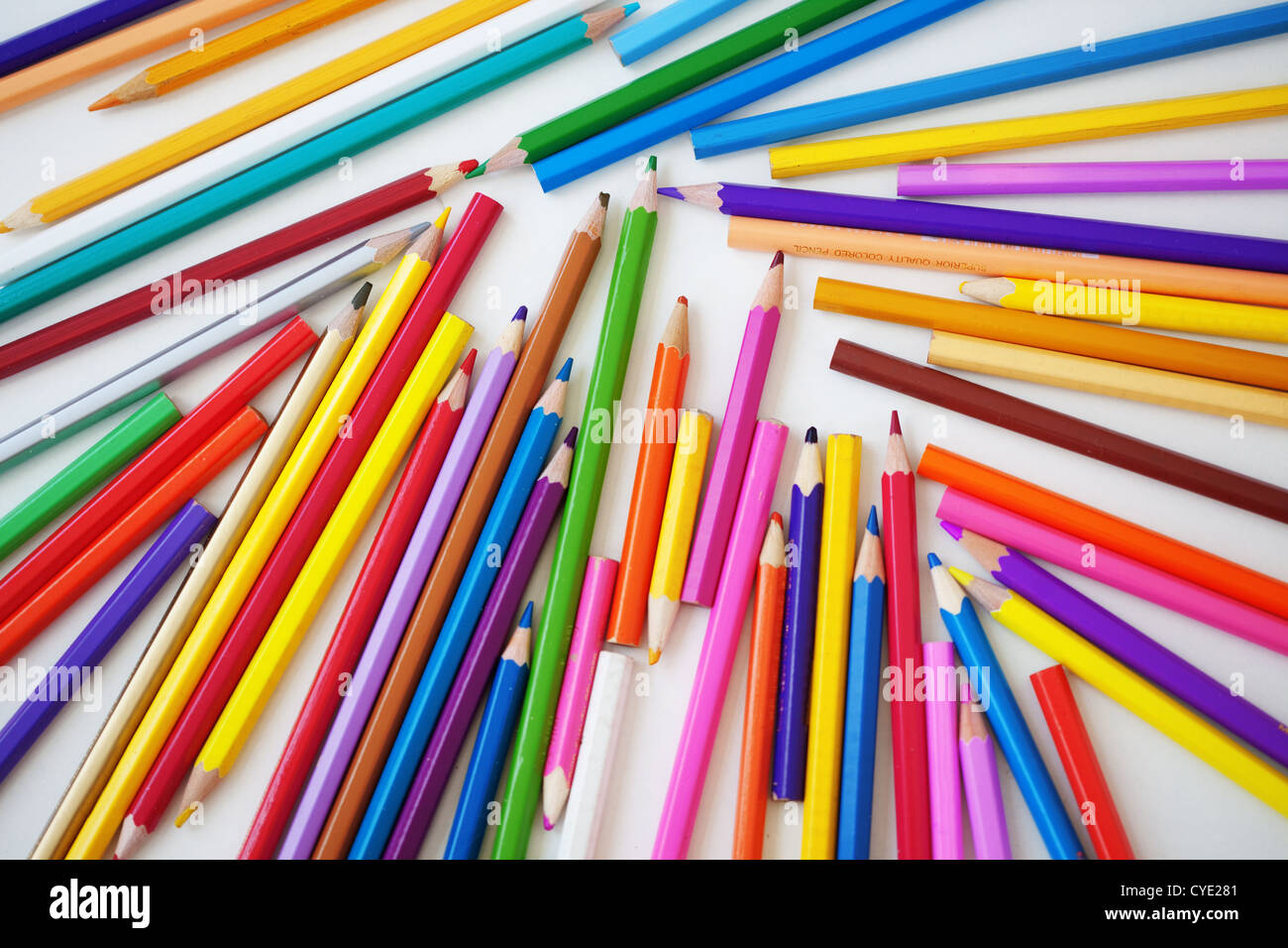 Many colorful pencils sparse on white table Stock Photo - Alamy