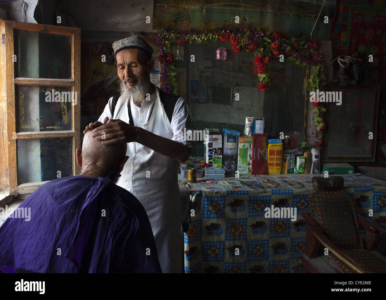 Uyghur Barber In His Shop Shaving The Head Of A Client, Minfeng ...