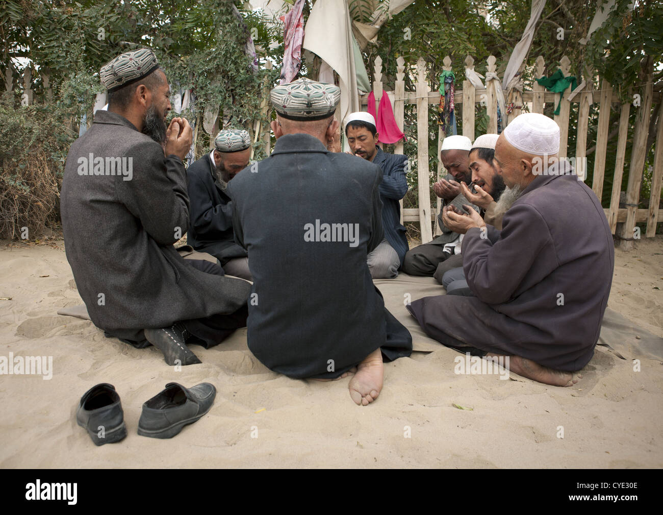 Uyghur Sufi Men Praying At Imam Asim Tomb In The Taklamakan Desert ...