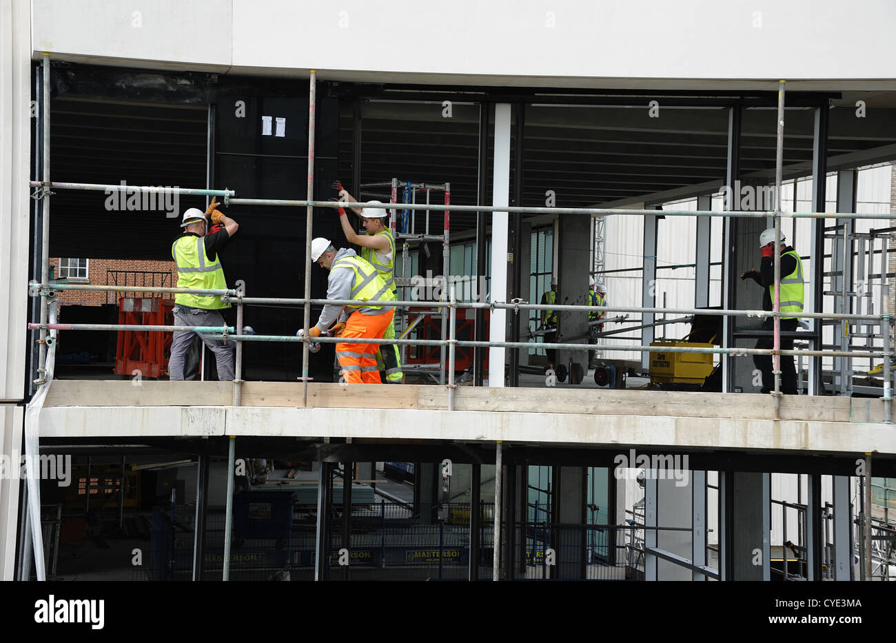 Builders install heavy glass panels in new building in London Stock ...