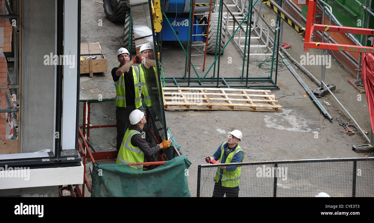 Builders installing large windows for new building in Northwest London ...
