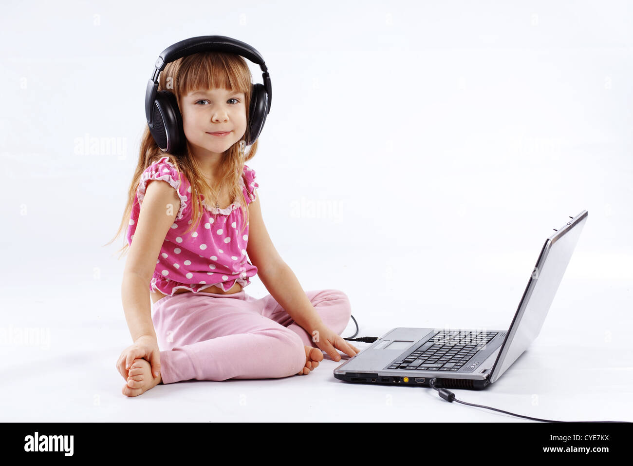 Portrait of funny modern child playing with computer and listening to ...