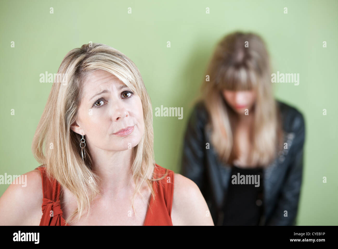 Mother with embarrassed or sad daughter in background Stock Photo - Alamy