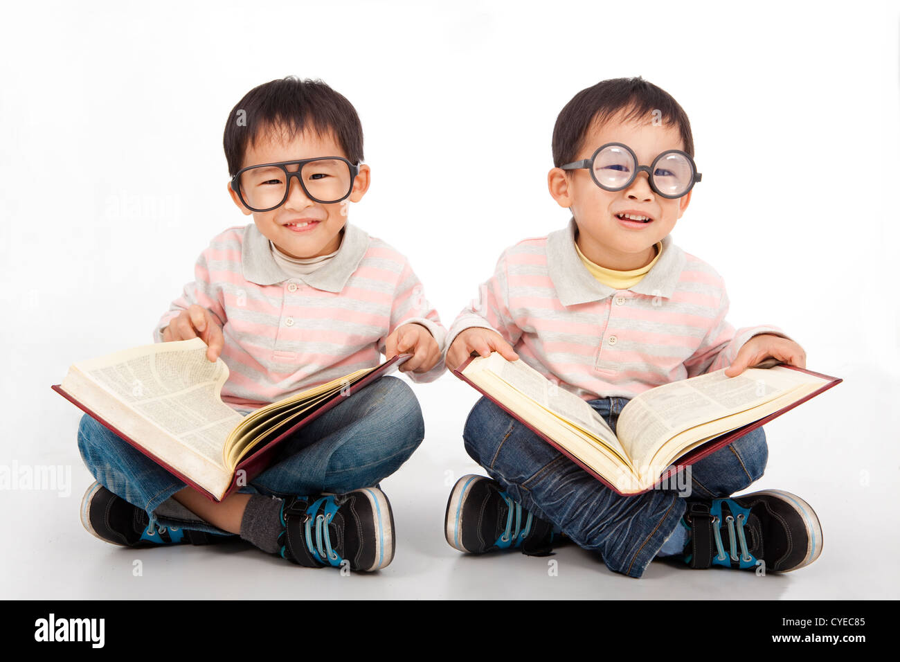 Happy kids with big book wearing black glasses Stock Photo - Alamy