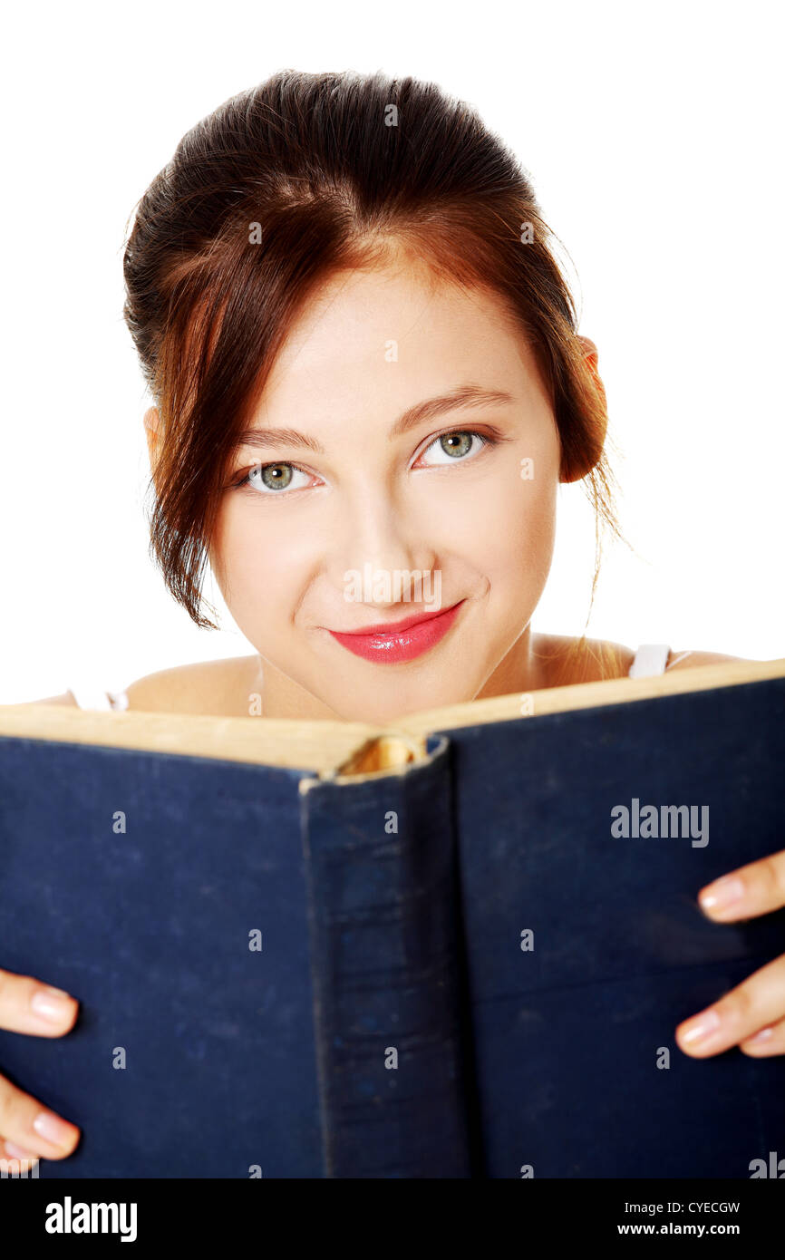 Closeup portrait of young pretty caucasian girl holding open book over ...