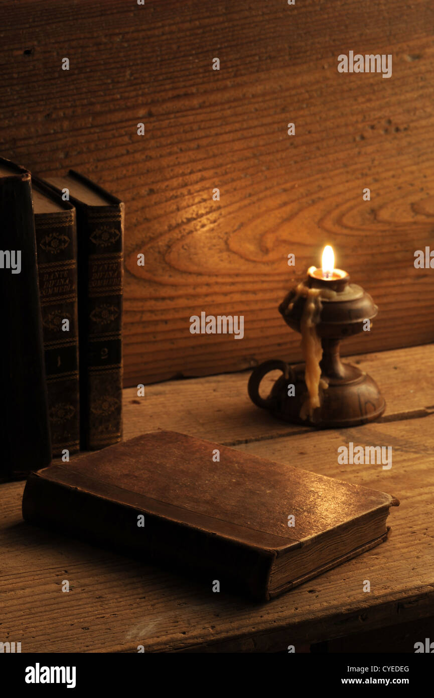 old book on a wooden table by candlelight Stock Photo - Alamy