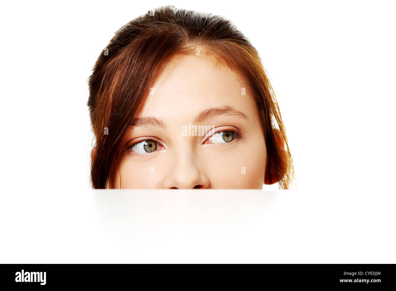Pretty teen brunette student hiding behind sheet of paper Stock Photo ...