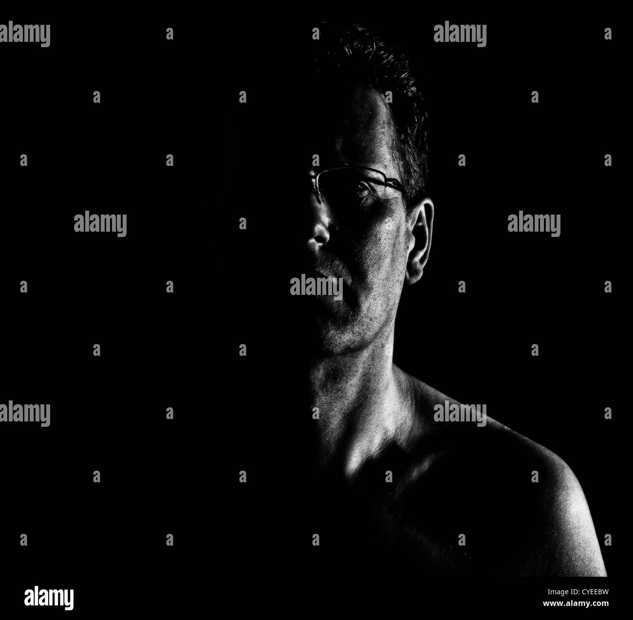 Man's coarse portrait in sidelight, he wear glasses Stock Photo - Alamy