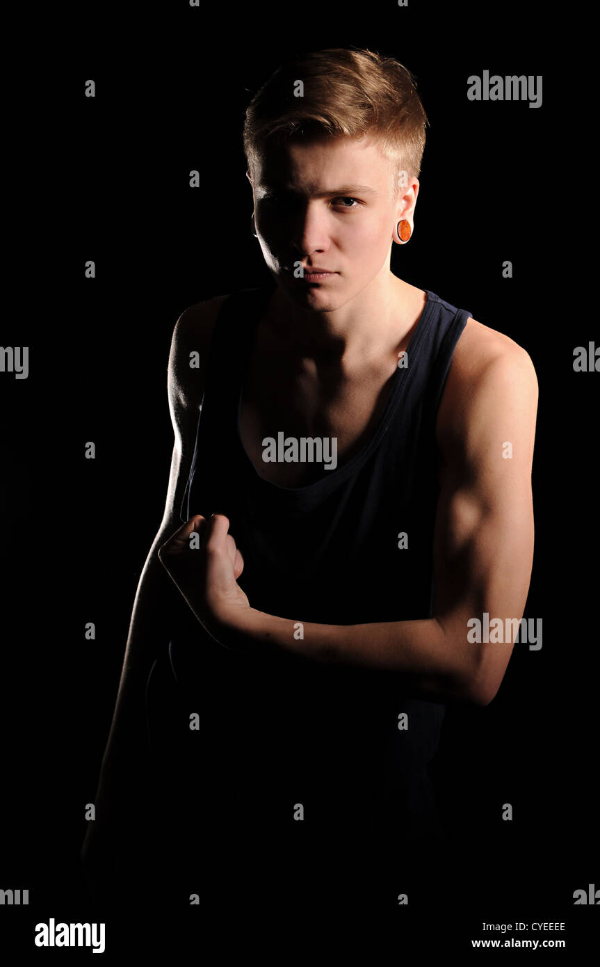 teenager showing muscles on the black background Stock Photo - Alamy