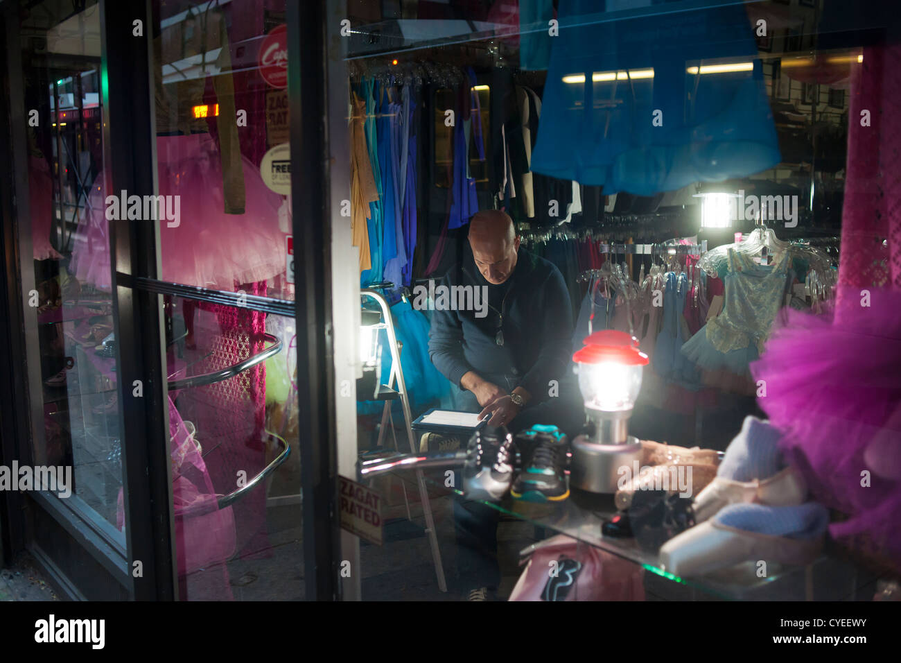 A worker in a store in New York consults his battery powered tablet ...