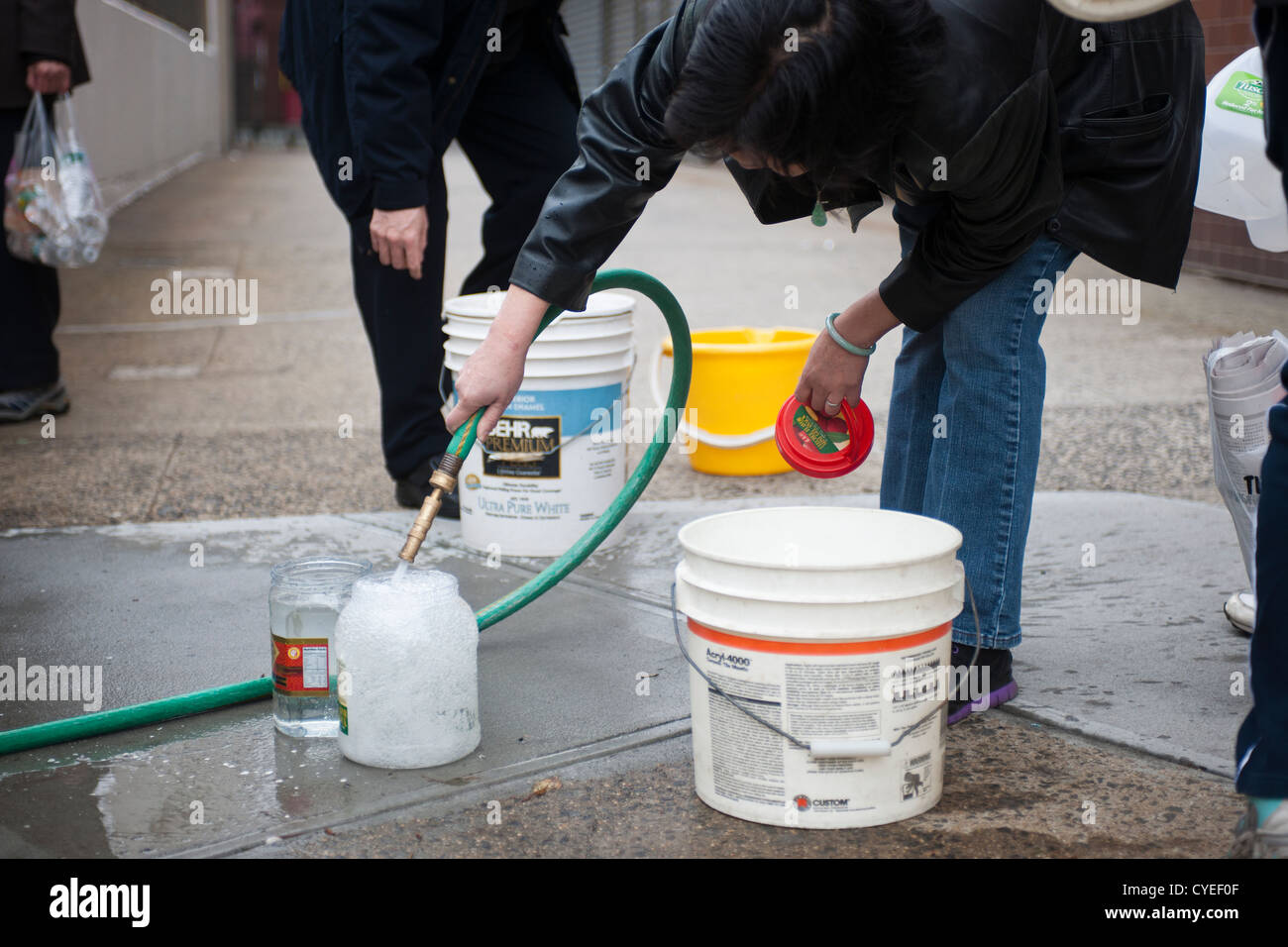 Residents without power from Hurricane Sandy fill buckets of water to ...