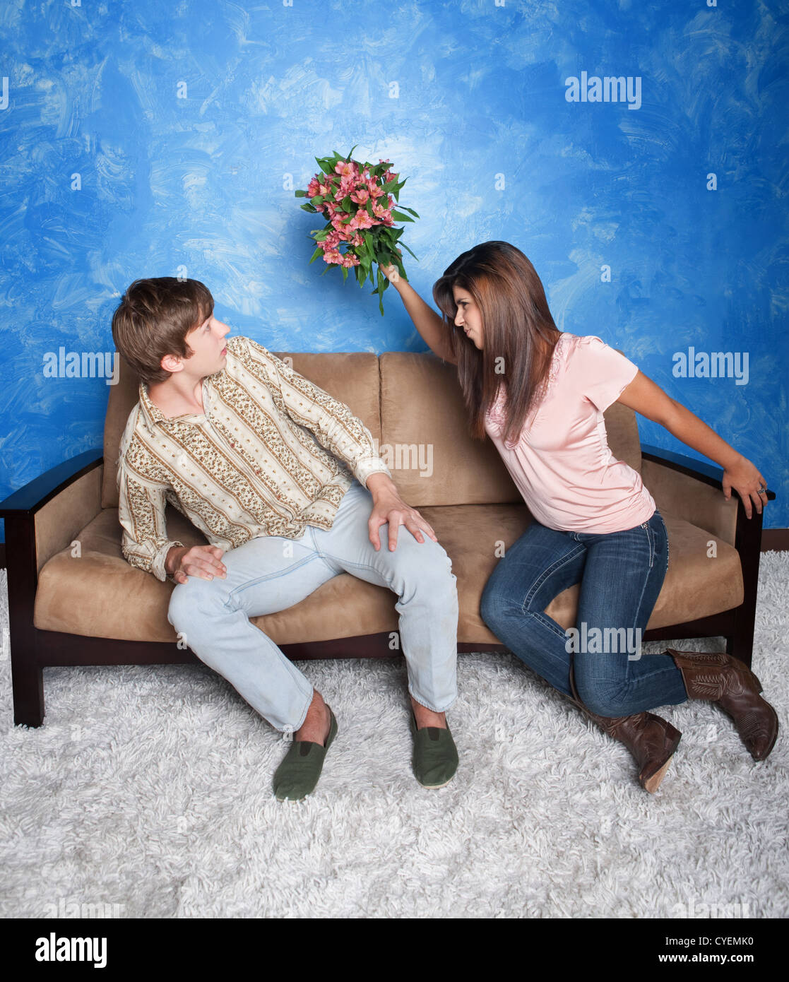 Angry girl gestures to hit boyfriend with flower bouquet Stock Photo ...
