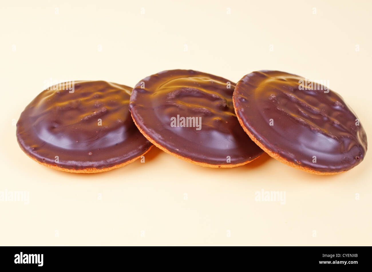 Three chocolate cookies yellow background close up Stock Photo - Alamy
