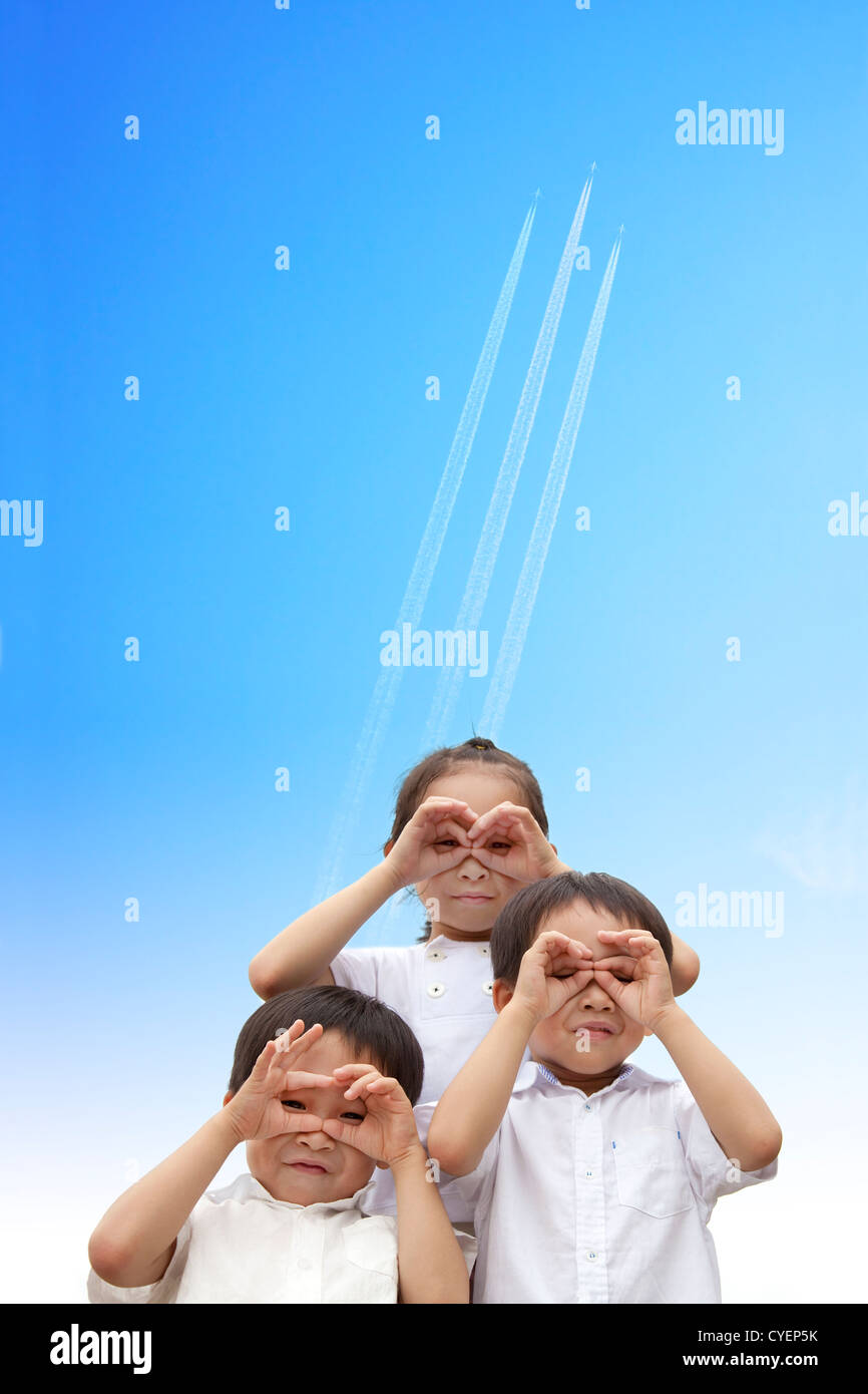 three happy kids watching the aircraft flying through to sky Stock ...