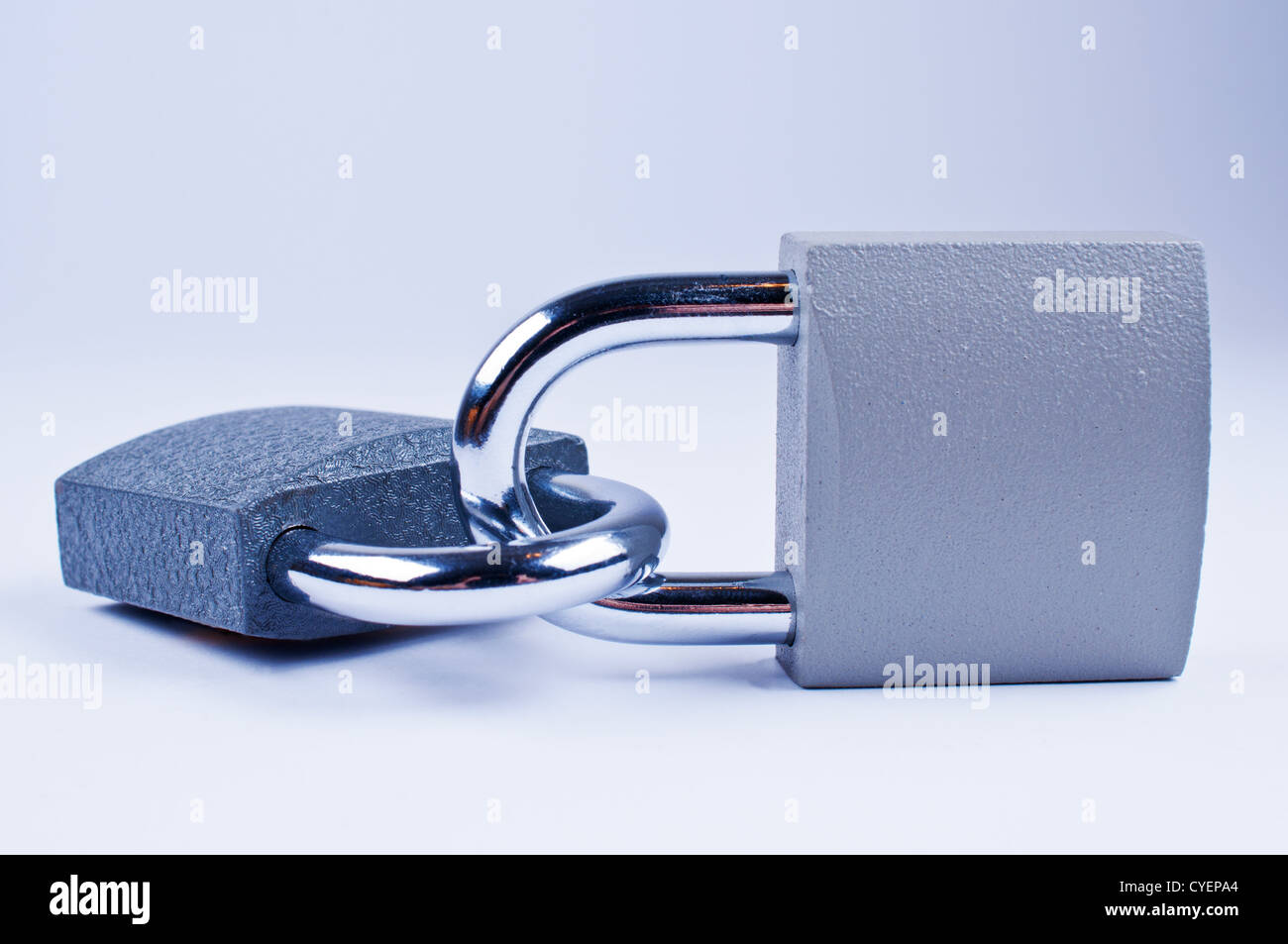 Two padlocks with a key on grey background Stock Photo - Alamy