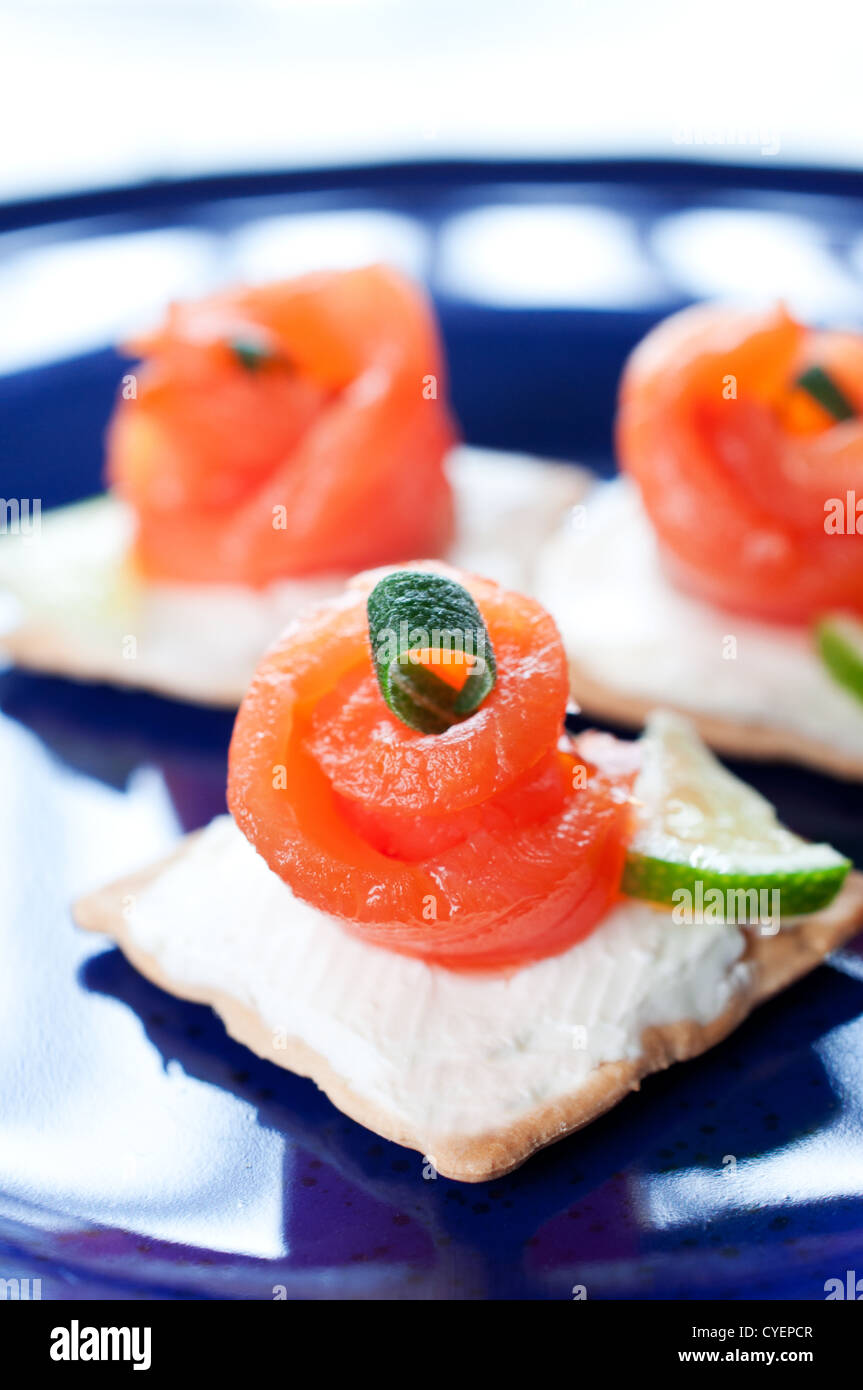 Canapes with smoked salmon and cream cheese on dark blue plate Stock ...