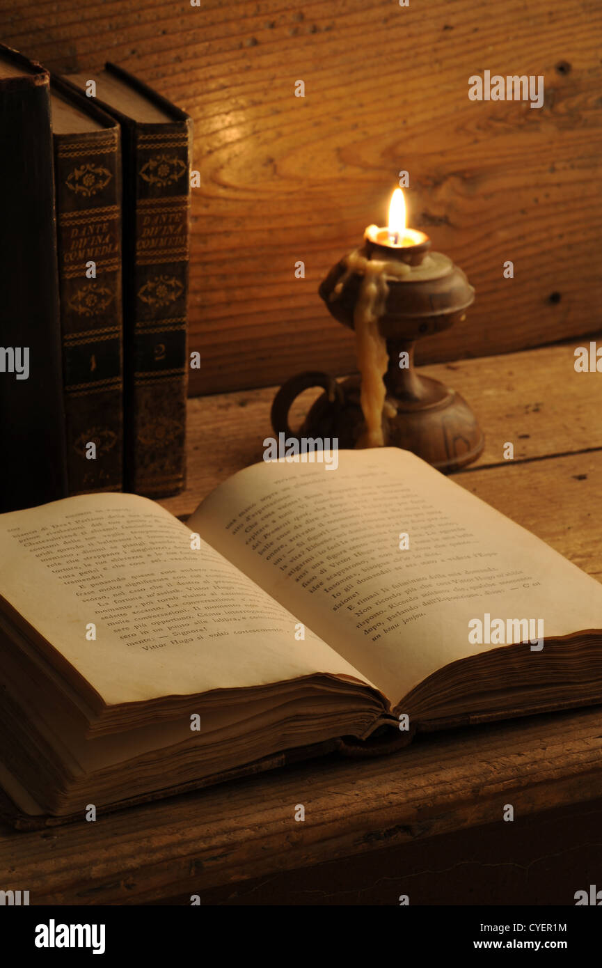 old book on a wooden table by candlelight Stock Photo - Alamy