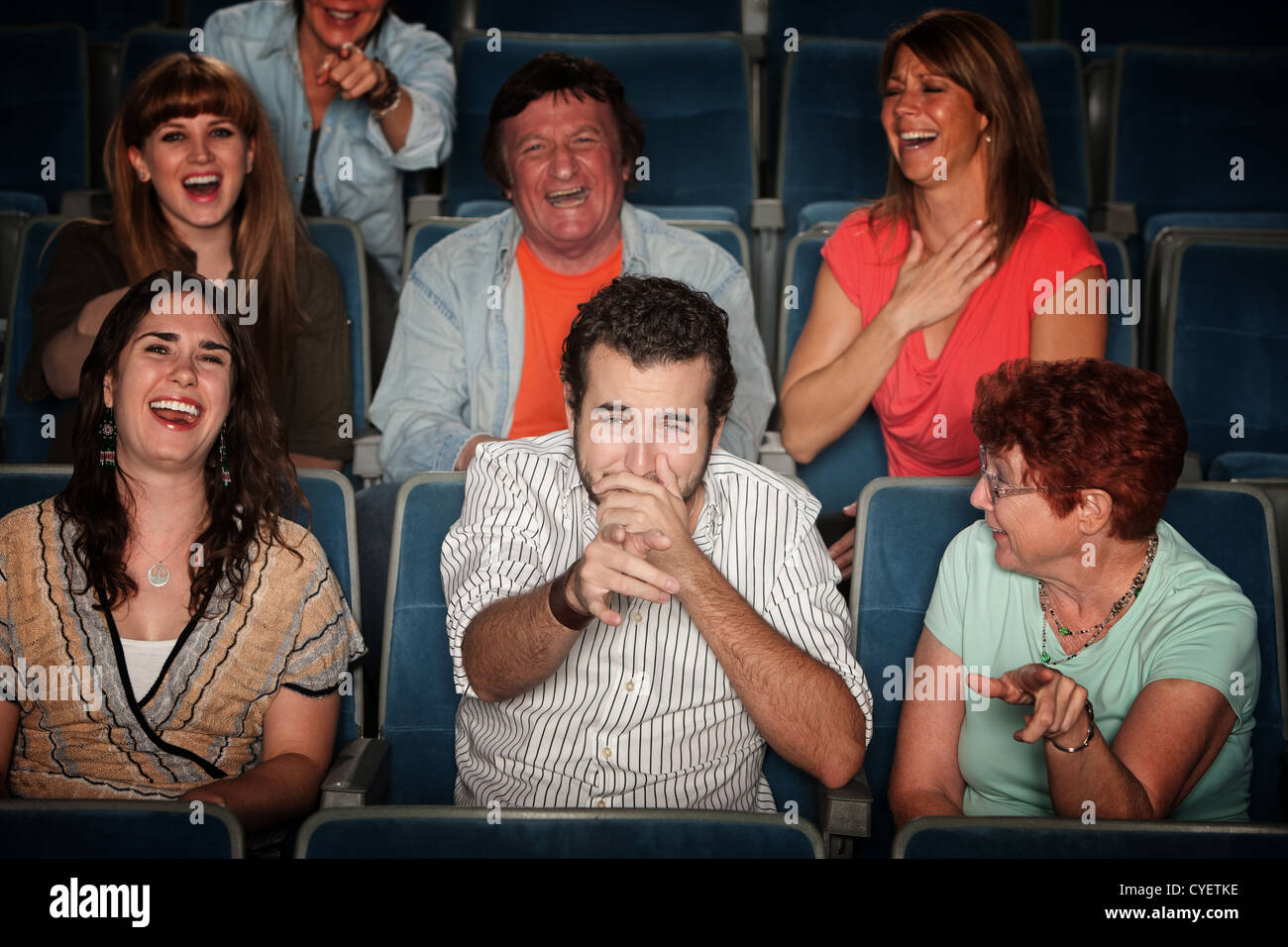 Group of seven audience watching movie laugh in theater Stock Photo - Alamy