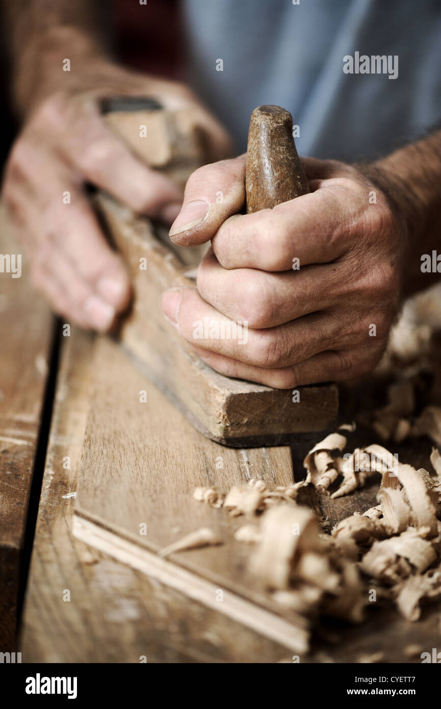 hands of a carpenter planing a plank of wood with a hand plane Stock ...