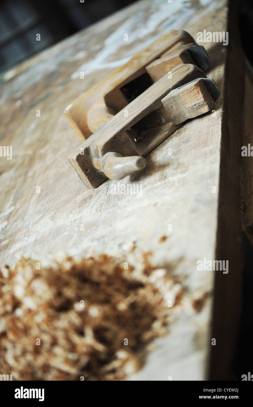 a work table of a carpenter with two hand planers and a pile of wood ...
