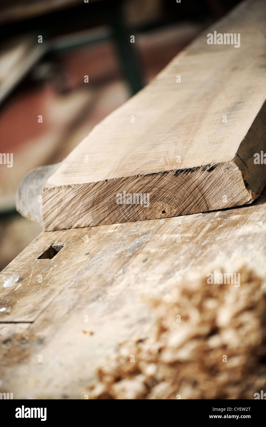 a work table of a carpenter with a wooden plank and a pile of wood ...