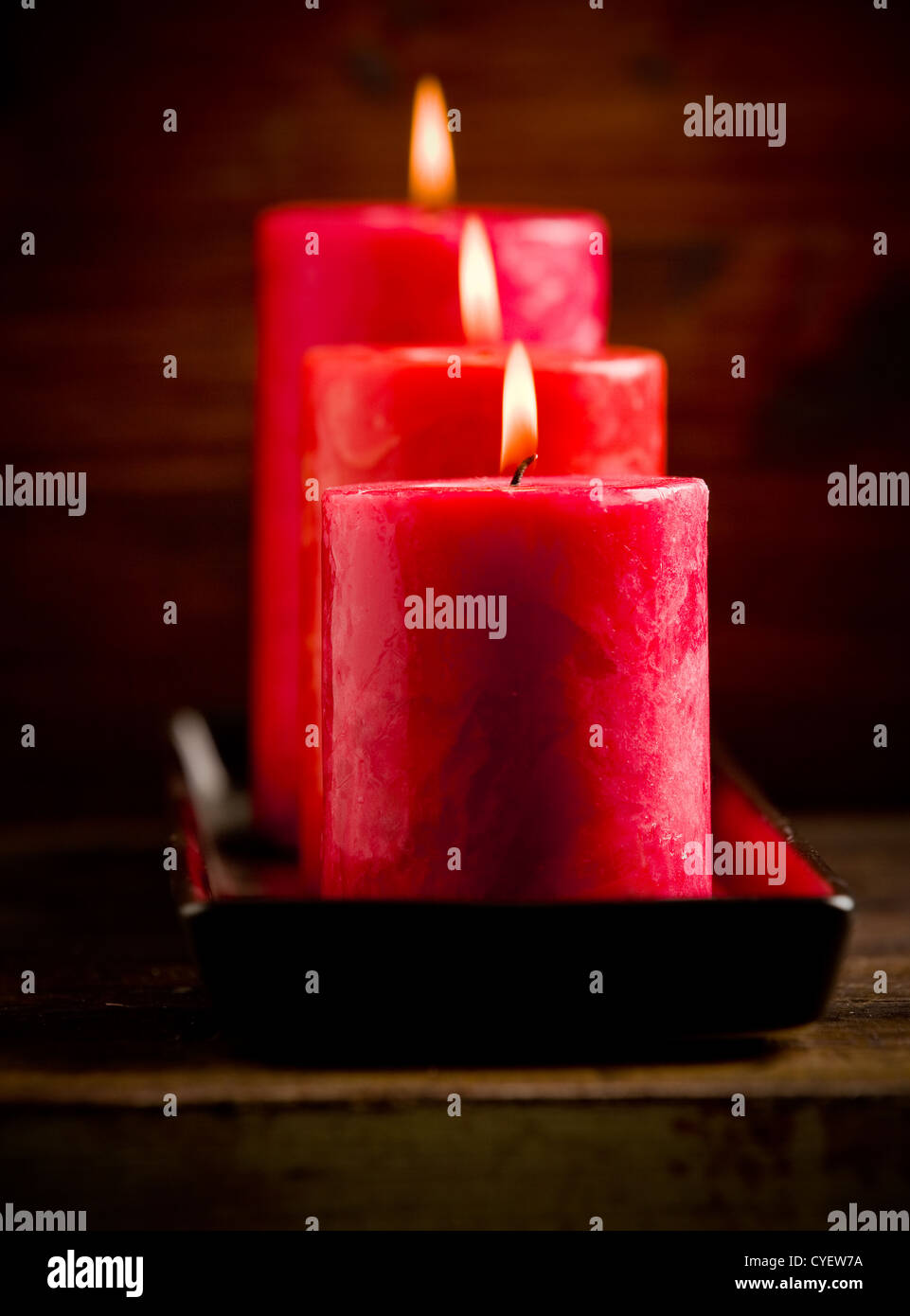 photo of red christmas candles on wooden table highlighted by spot ...