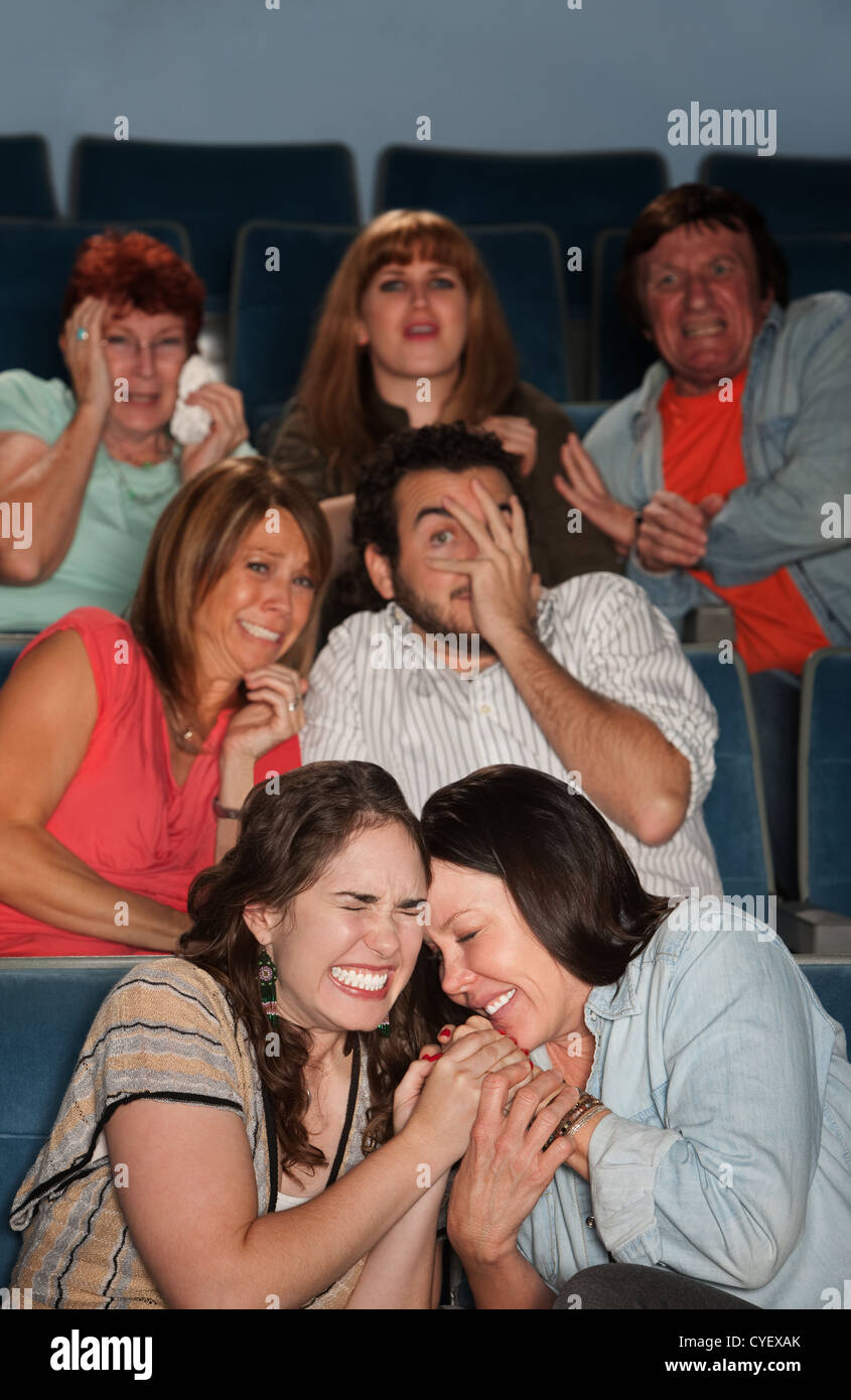 Group of scared people watch horror movie in theater Stock Photo - Alamy