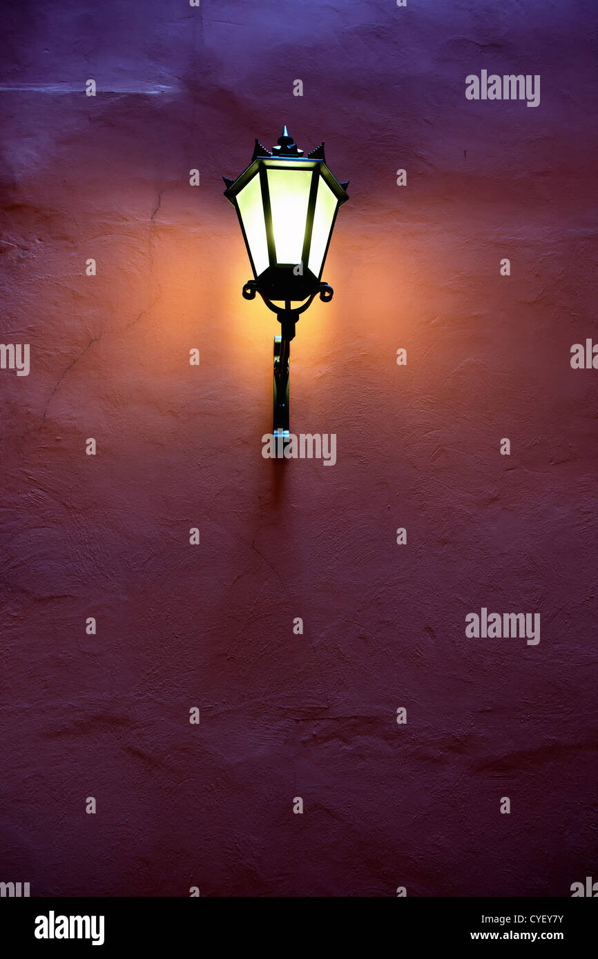 Old yellow light shining on the purple wall Stock Photo - Alamy
