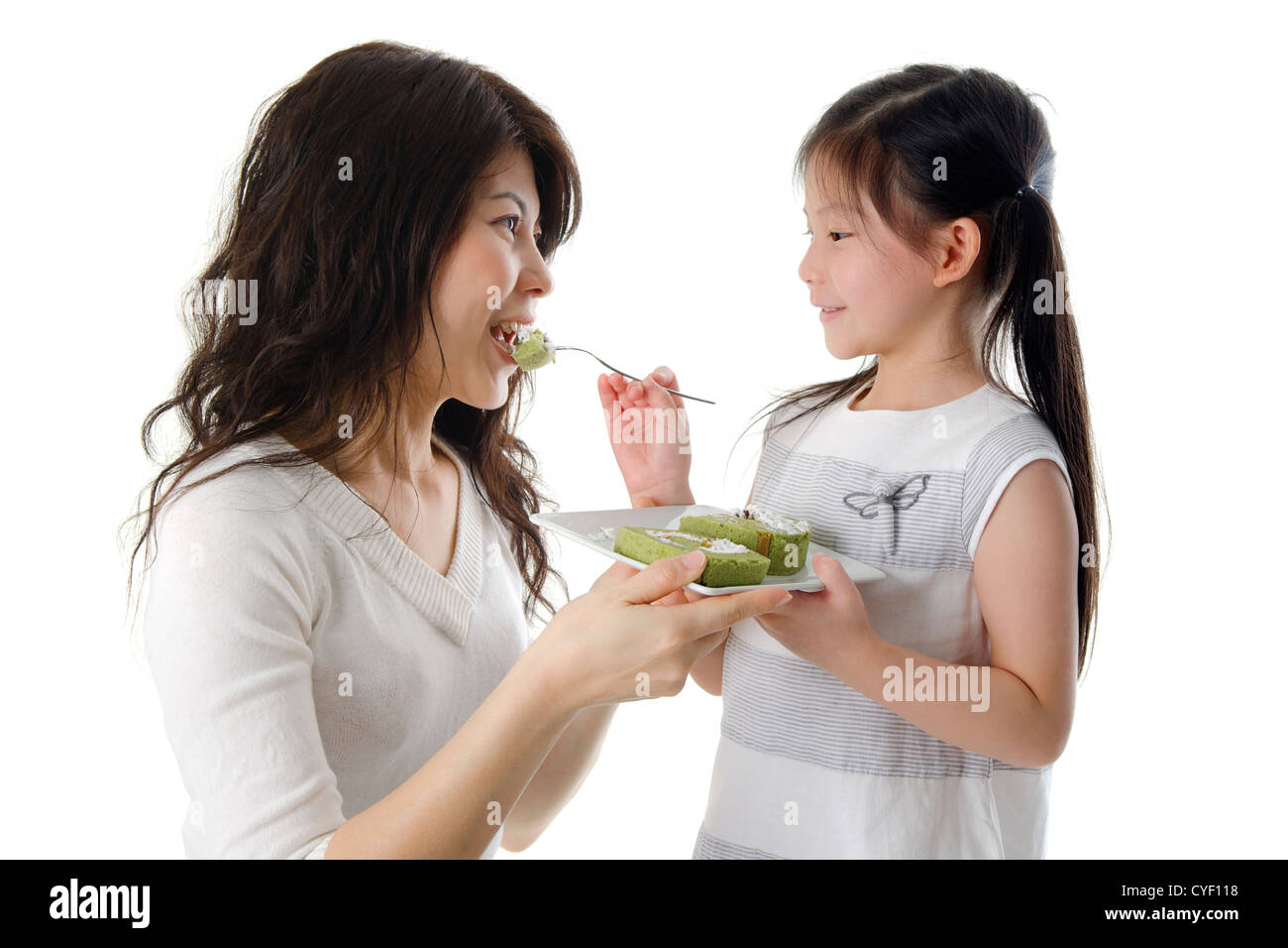 Little Asian girl feeding cake for her mother Stock Photo - Alamy