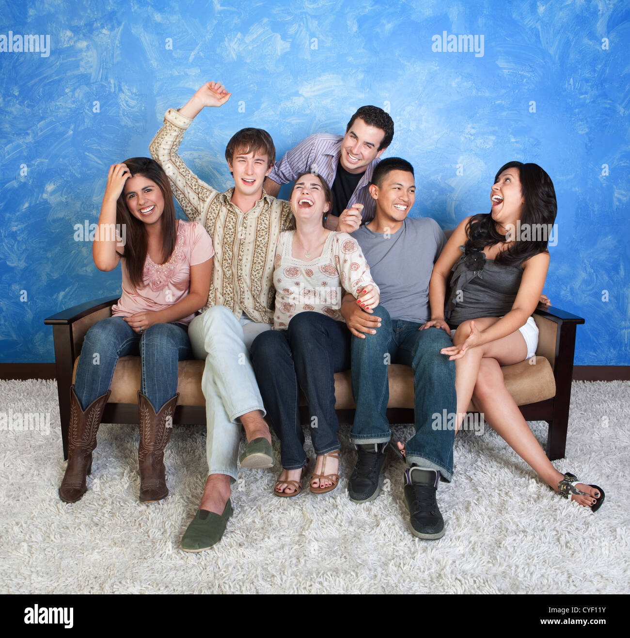 Group of six happy teens on sofa laugh together Stock Photo - Alamy