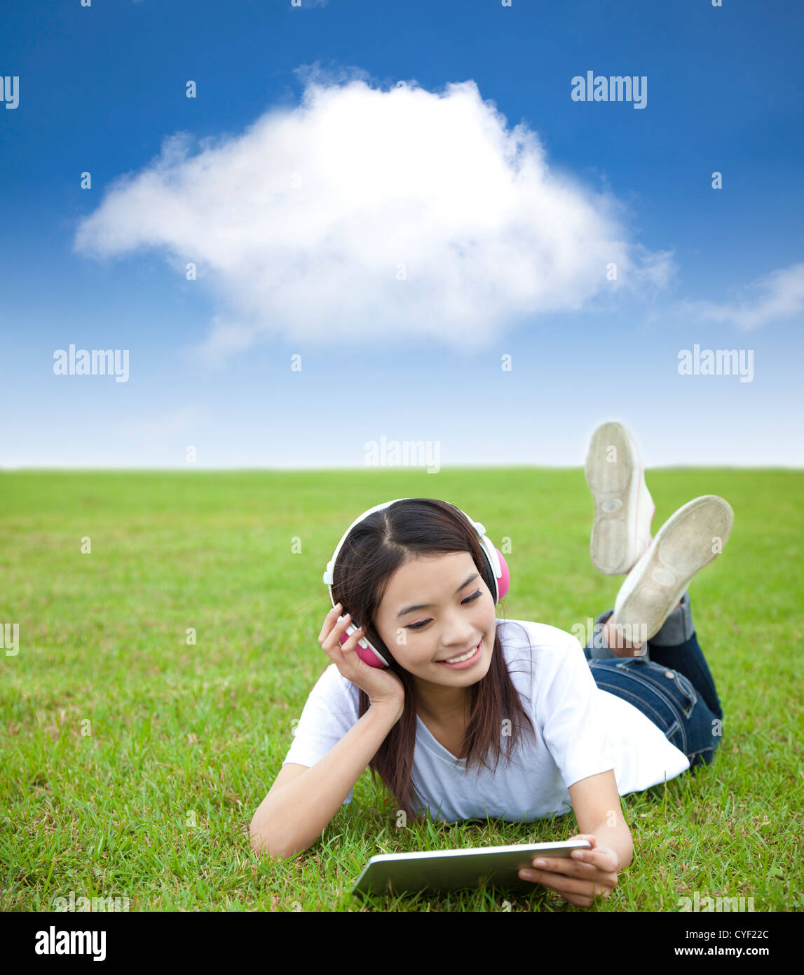 happy girl using touch pad computer with headphone on the meadow Stock ...