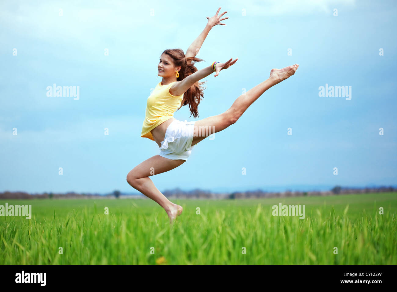 Young beautiful girl doing gymnastic jumps outdoors Stock Photo - Alamy