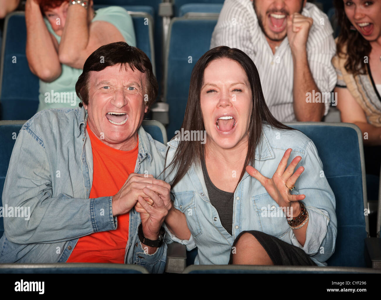 Scared couple and group of people scream in a theater Stock Photo - Alamy