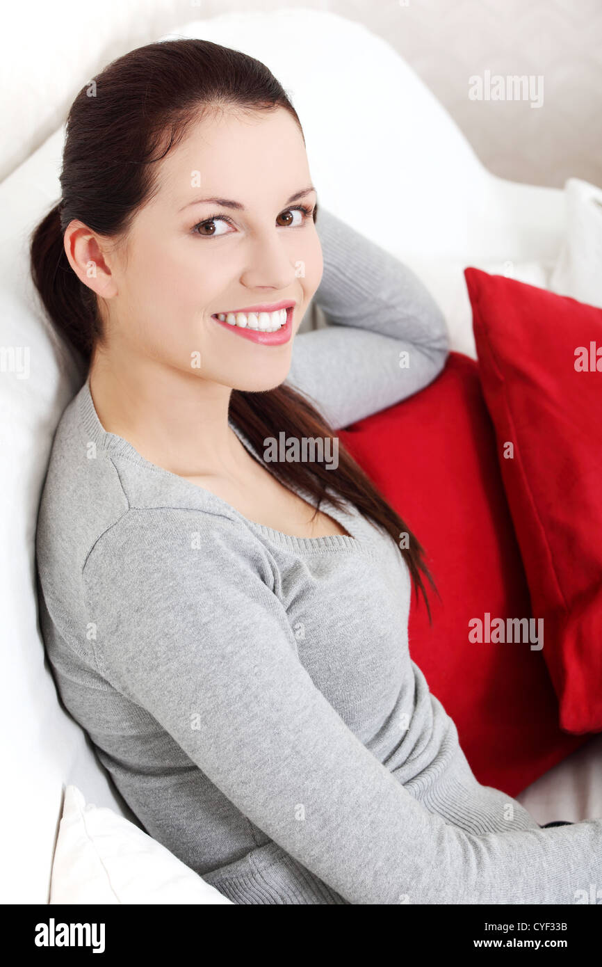 Beautiful smiling woman sitting on a sofa Stock Photo - Alamy