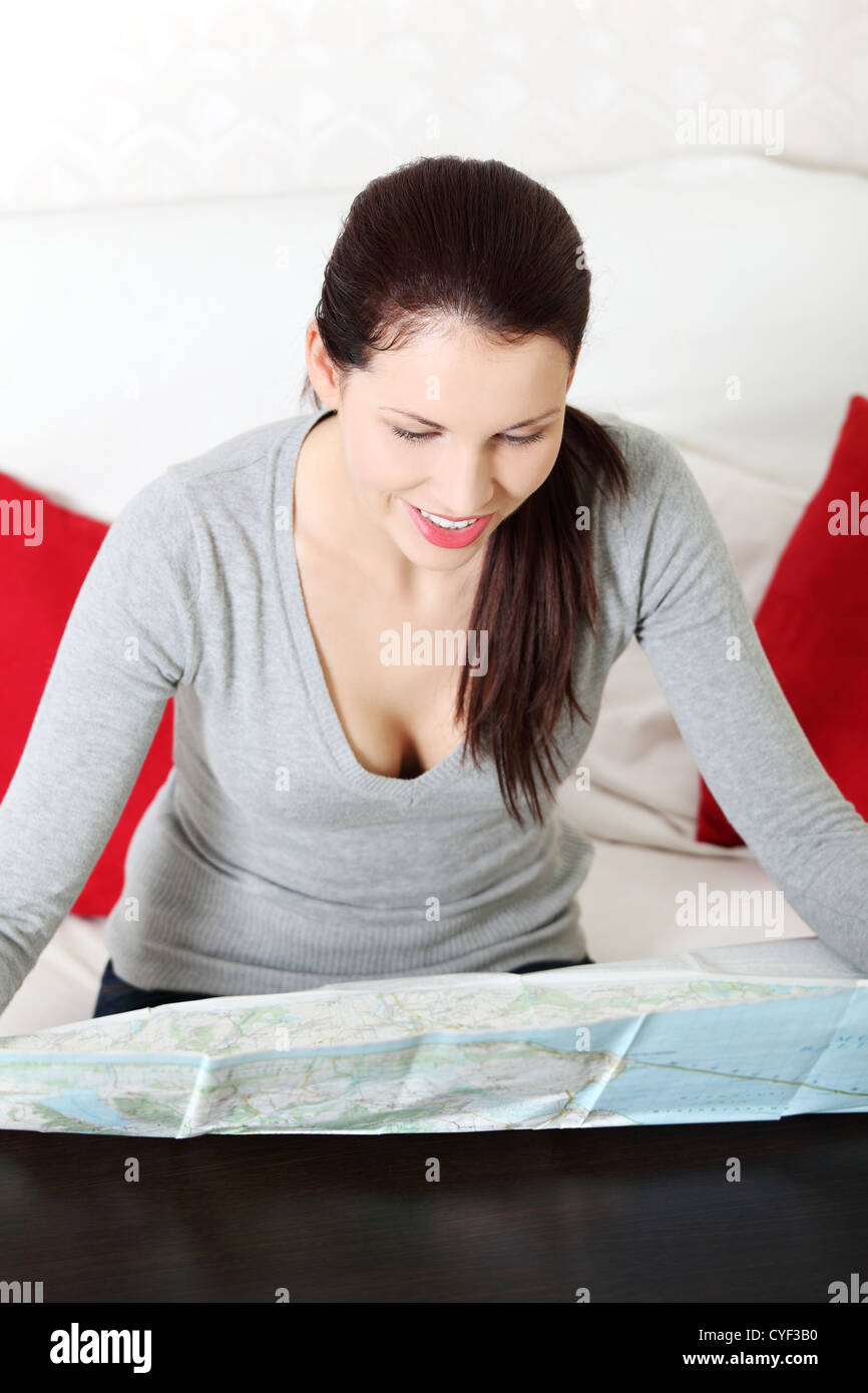 Front view portrait of a young beautiful woman, sitting on a couch at ...