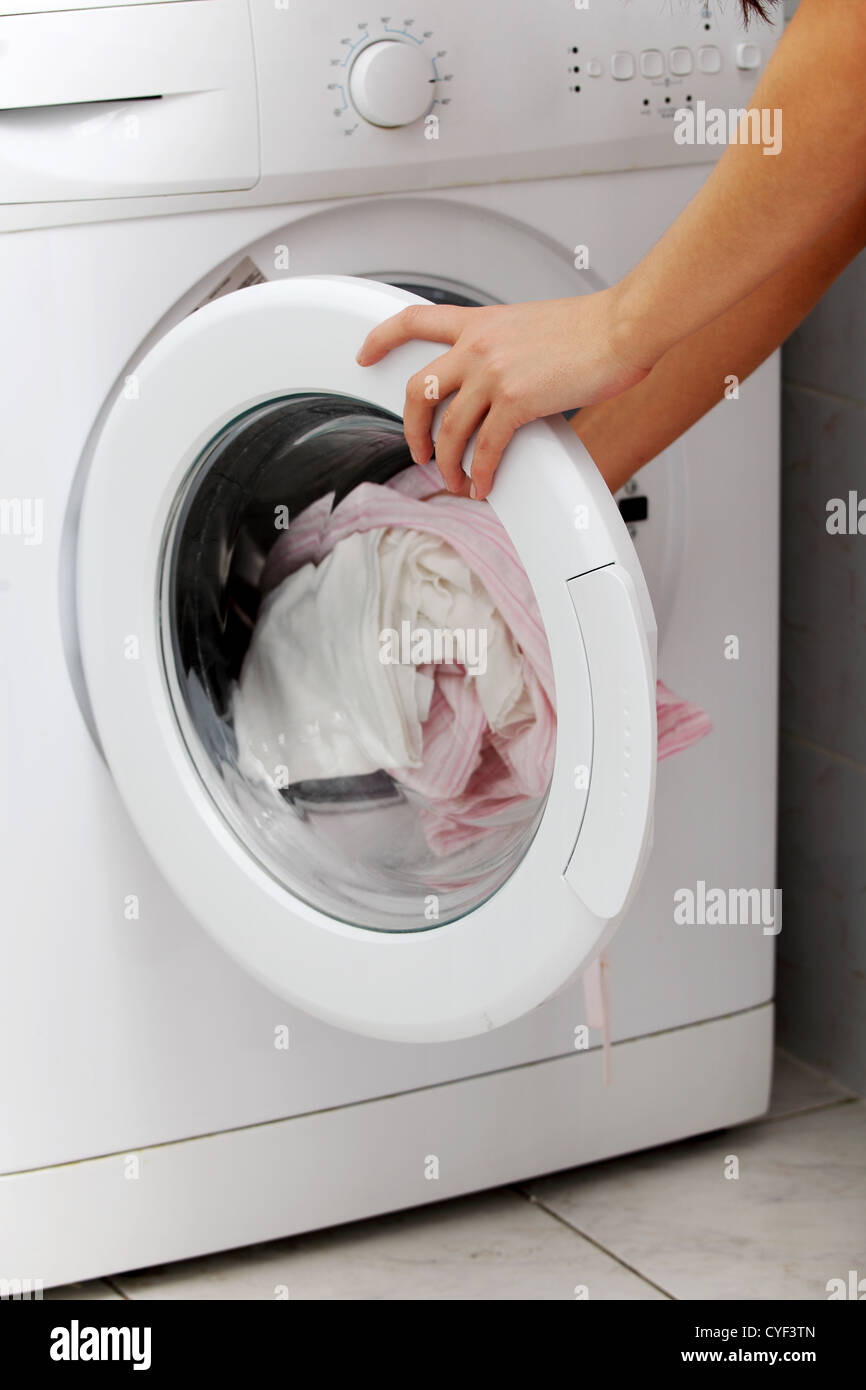 Closeup of a laundry being put into the washing machine Stock Photo - Alamy