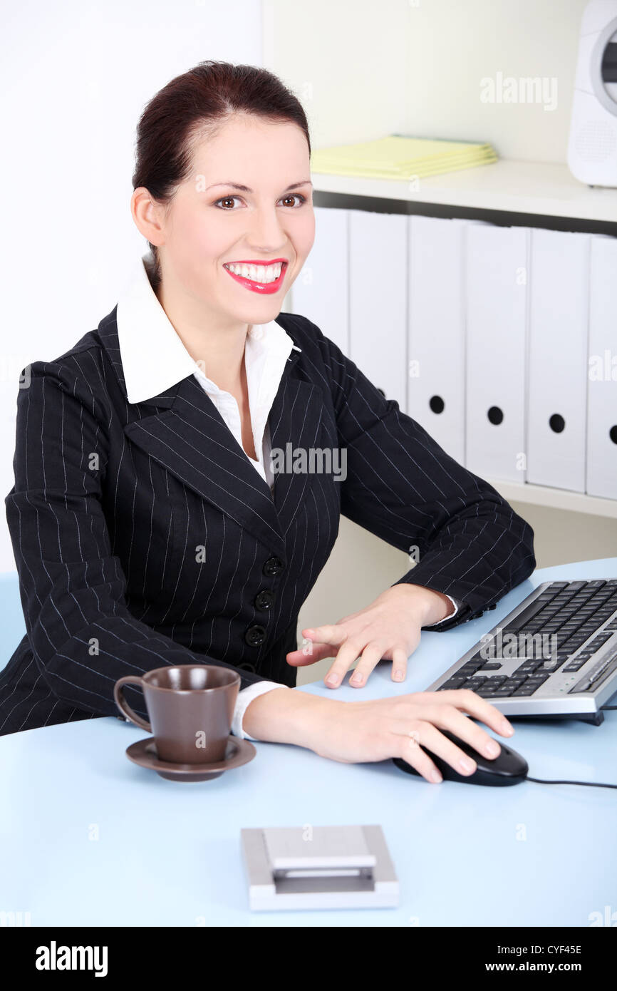 Portrait of a beautiful young smiling business woman sitting behind the ... Portrait of a beautiful young smiling business woman sitting behind the ...