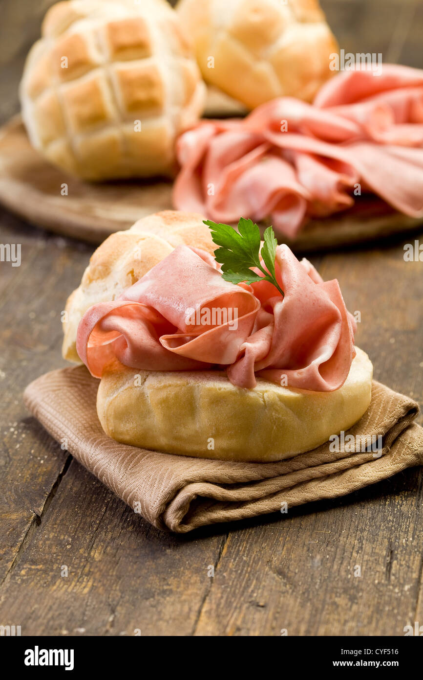 delicious sandwich on wooden table with mortadella sausage Stock Photo ...
