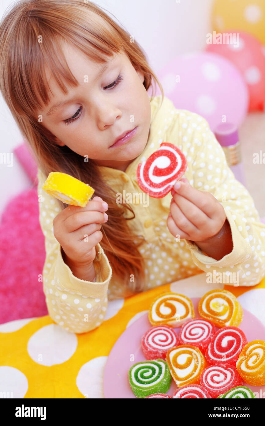 Cute child eating candies at home Stock Photo - Alamy