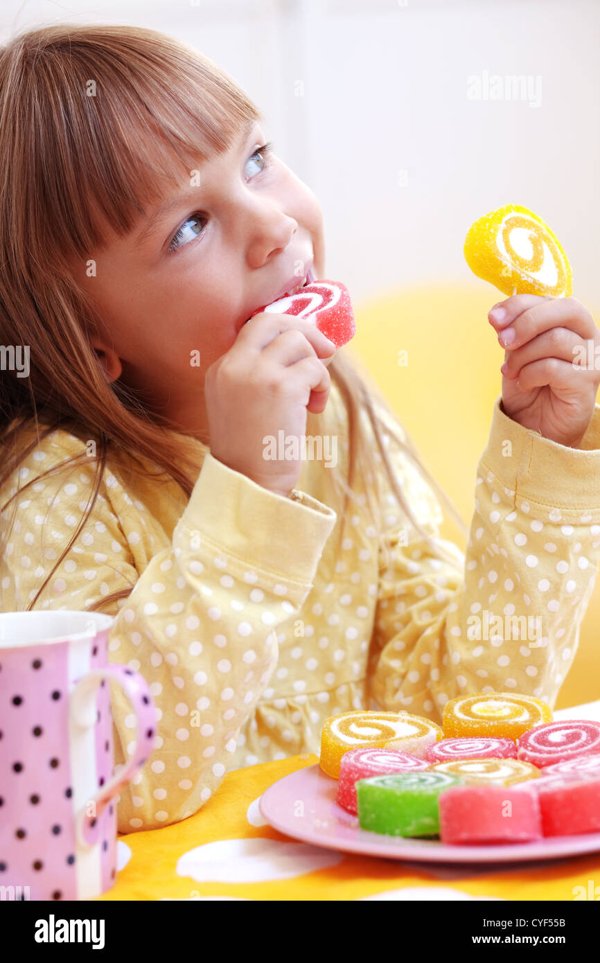 Cute child eating candies at home Stock Photo - Alamy