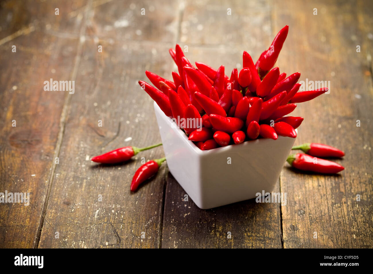 photo of red hot chili peppers inside a bowl on wooden table Stock ...