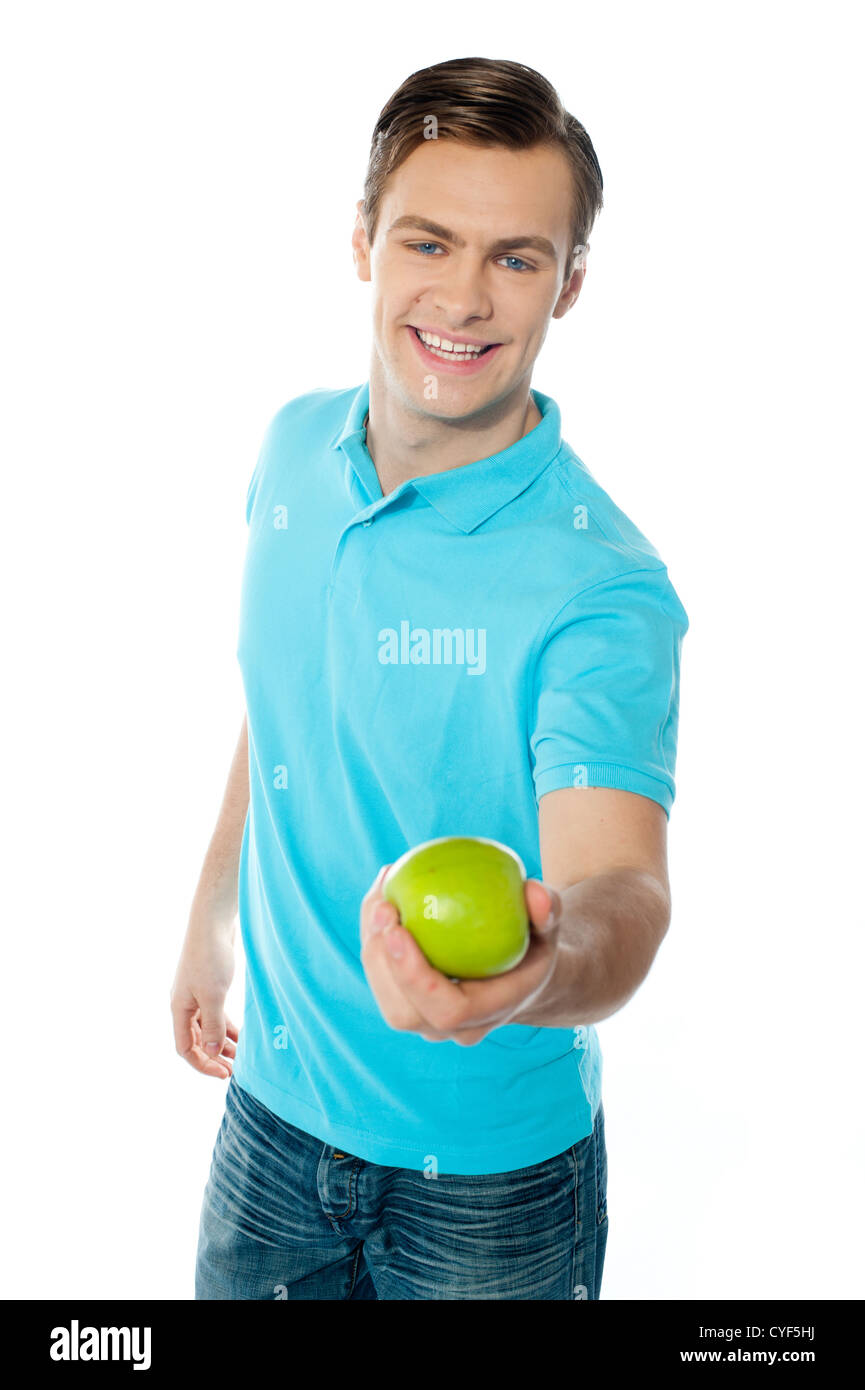 Good looking healthy guy offering a green apple isoalted over white ...