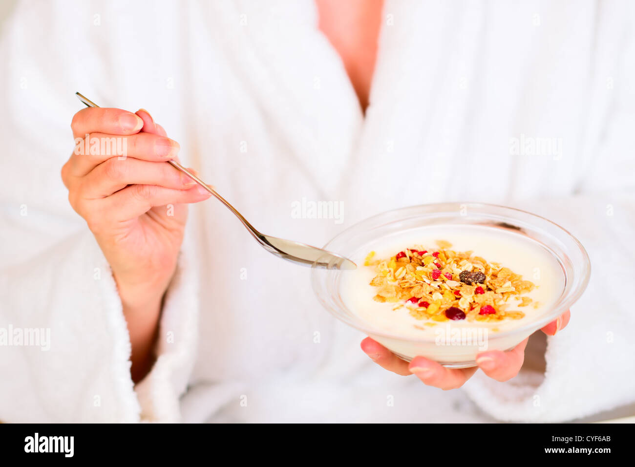 Woman hold yogurt plate on hand and she use spoon soon Stock Photo - Alamy