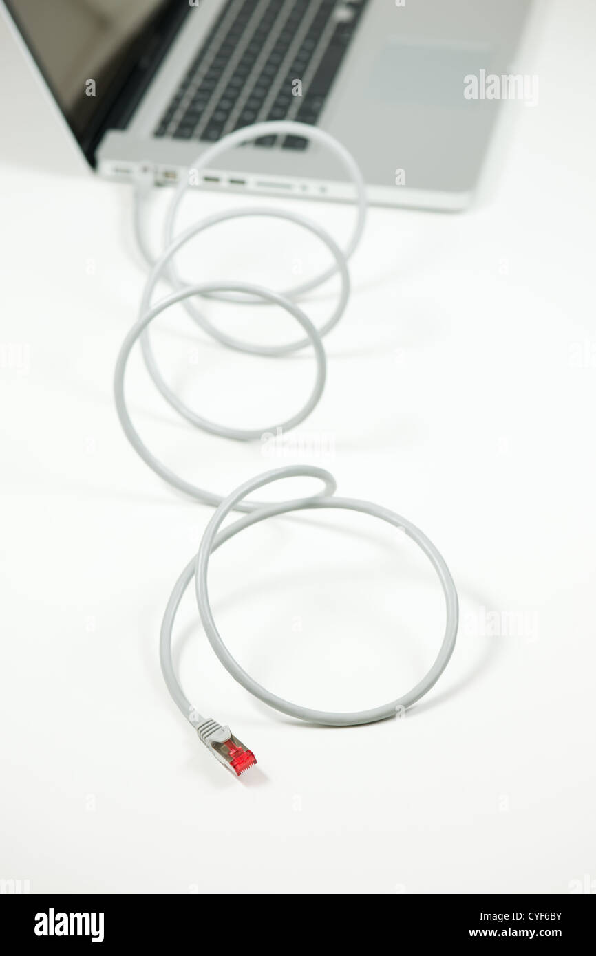 Laptop and the unconnected ethernet cable on the white table Stock ...