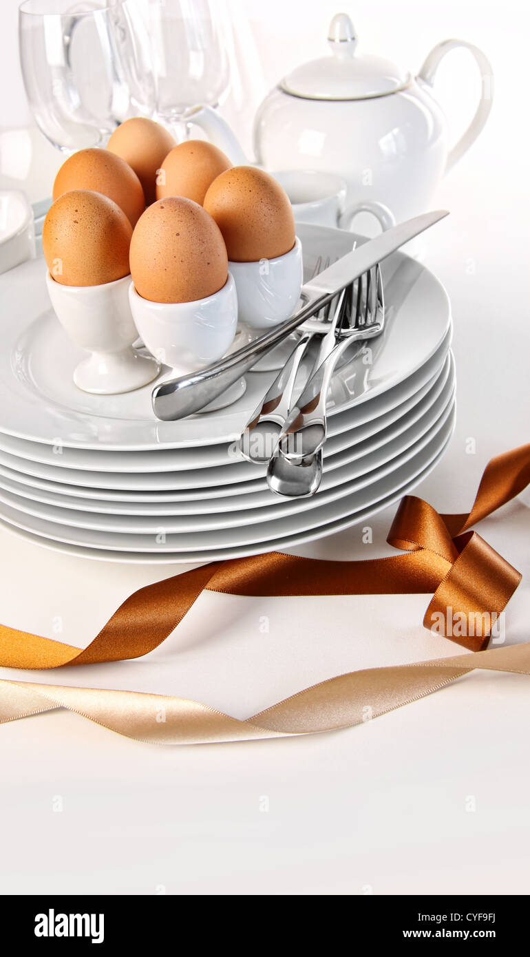 Brown eggs with plates for Easter breakfast on white Stock Photo - Alamy